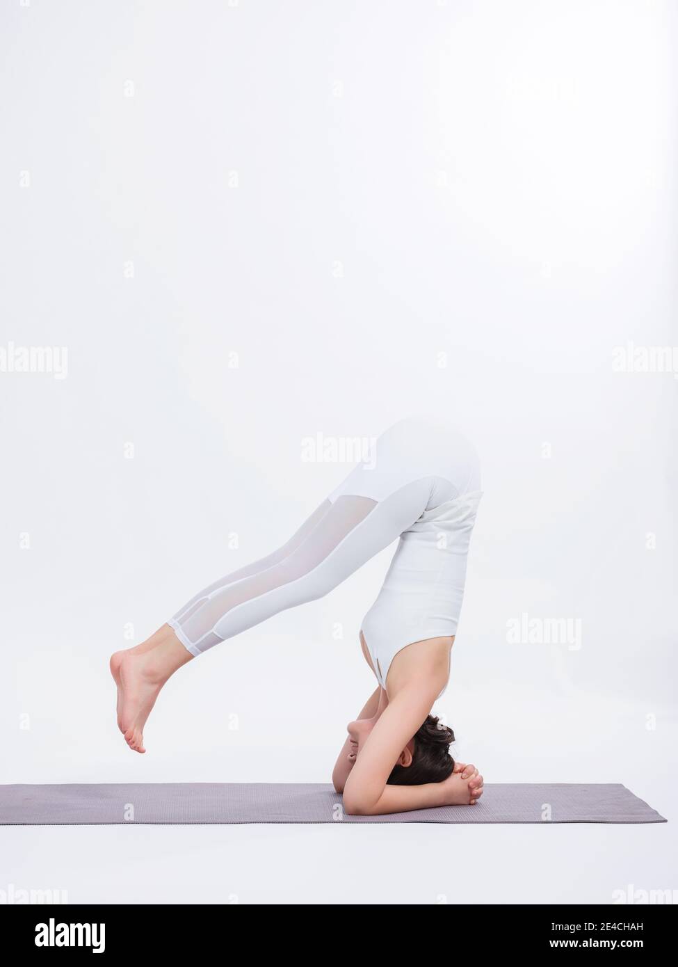Young women practice yoga standing upside down Stock Photo - Alamy