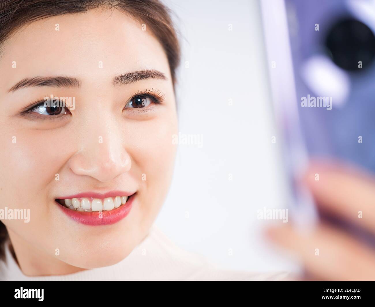 Young smiling women take self portraits with mobile phones Stock Photo ...