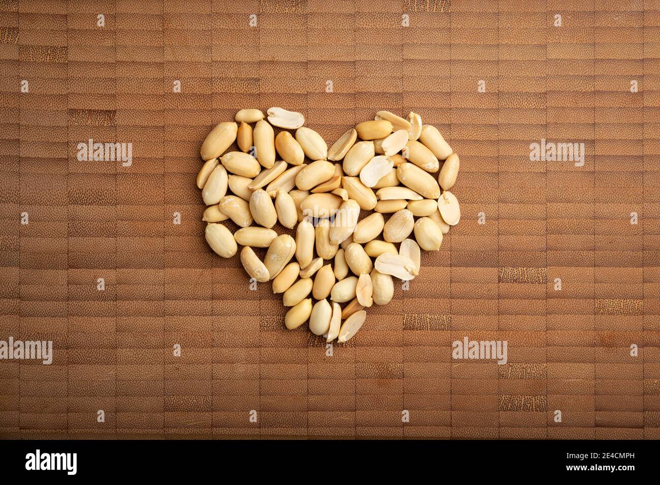 love concept image of heart shape made of peeled peanuts on bamboo ...