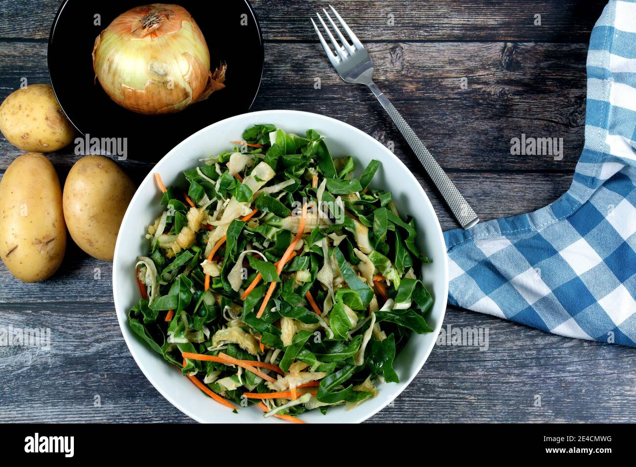 Vertical closeup of fresh vegetable salad on a black bowl with white ...