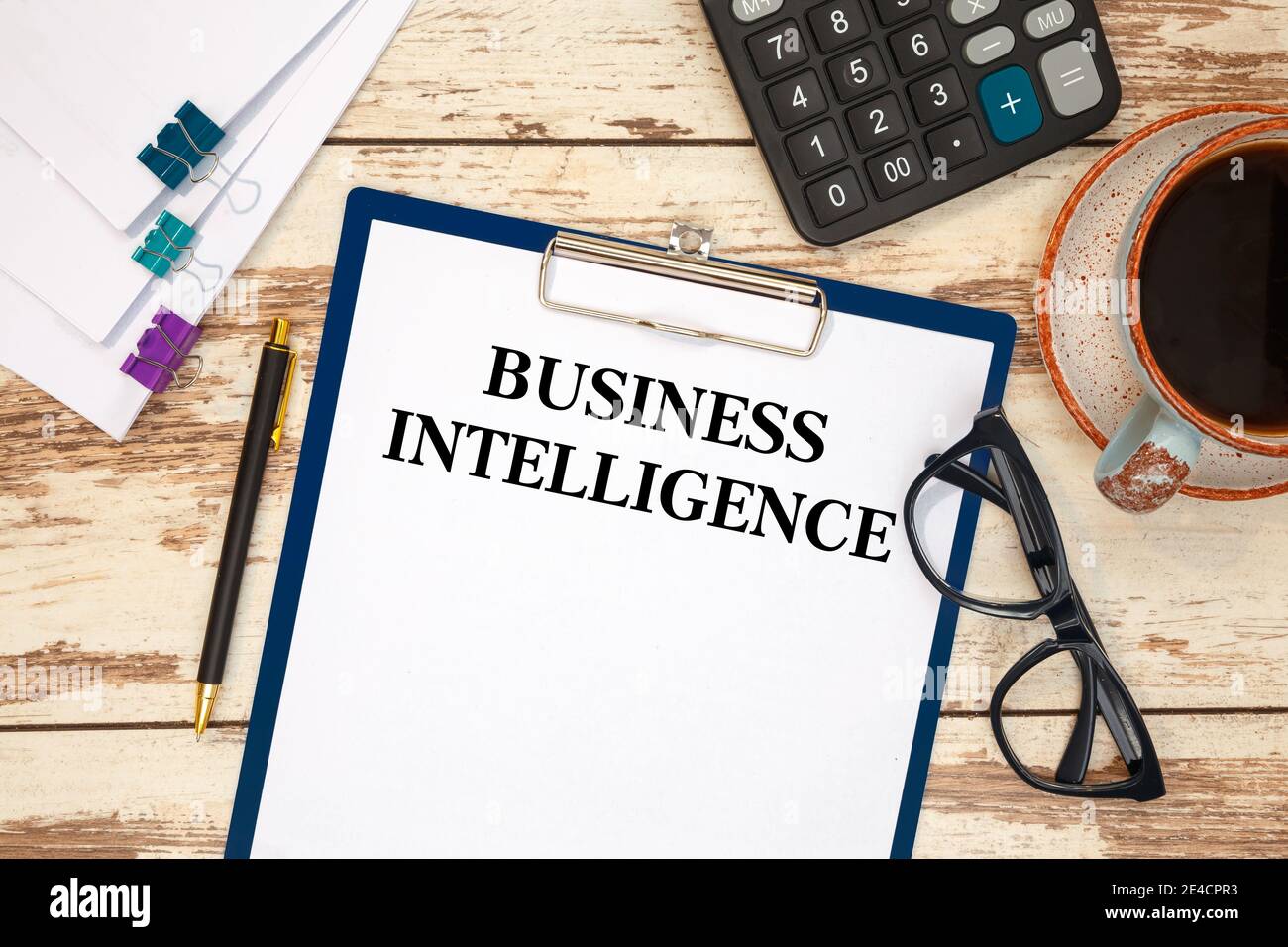 BUSINESS INTELLIGENCE is written in a document on the office desk with ...