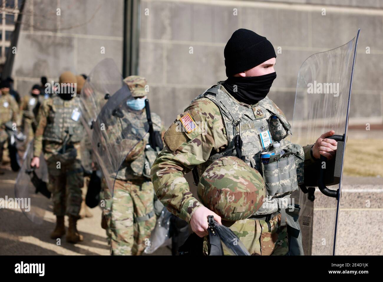 National Guard troops carry shields while repositioning at the United ...