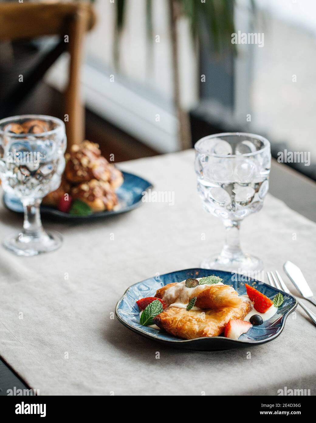 Table served with pastry desserts and glasses Stock Photo - Alamy