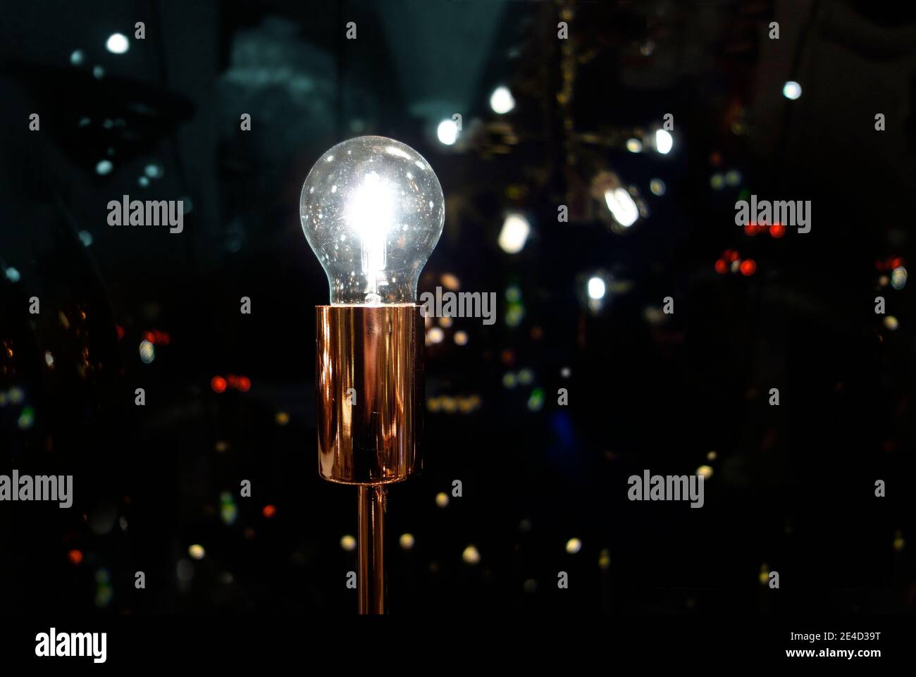 Sparkling Light bulb with night time modern urban background ...