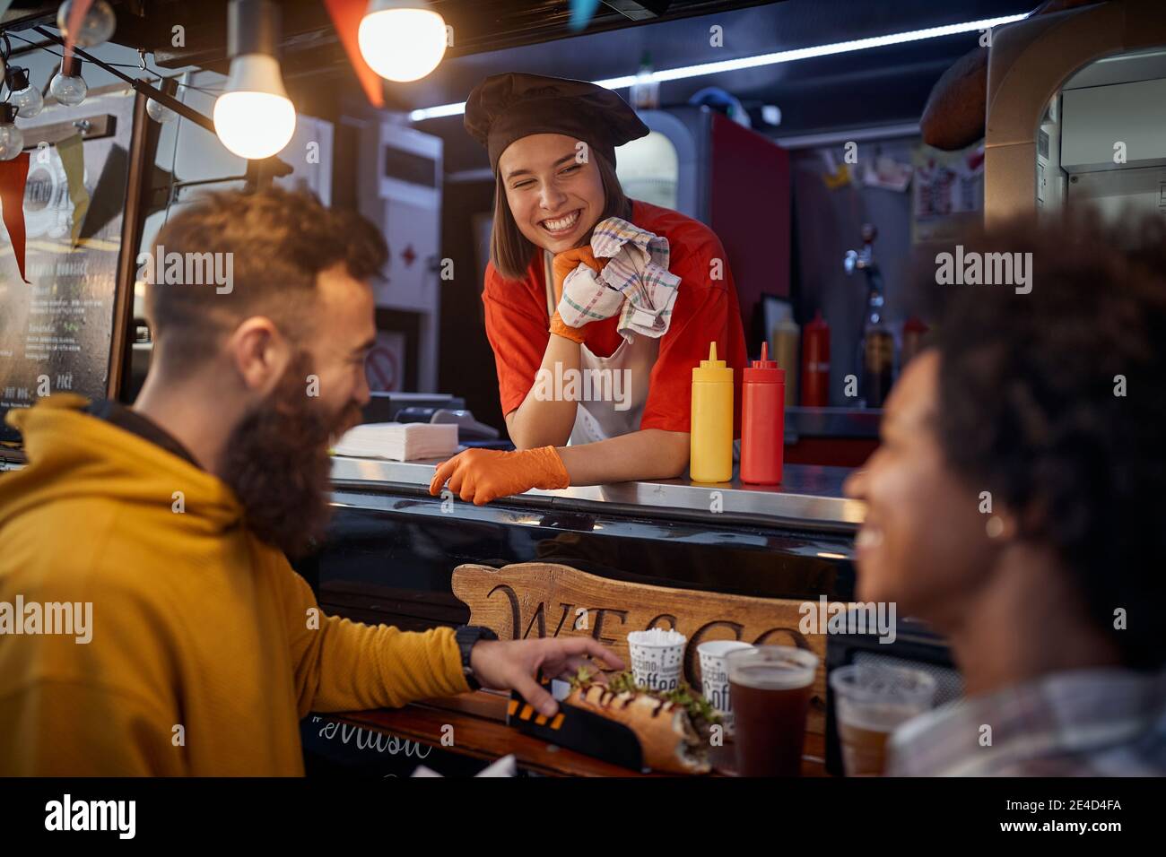 friends having a snack and a chit chat with an employee in fast food ...