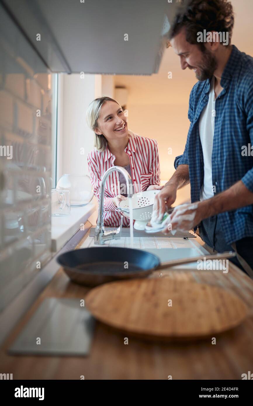 House husband washing dishes in the kitchen sink hi-res stock ...