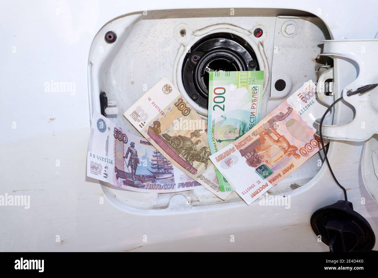 Money sticking out of automobile fuel closed tank concept Stock Photo ...