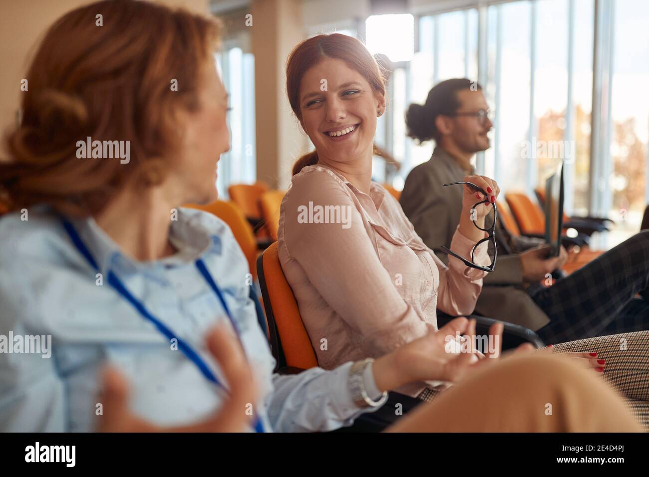 people in conference room at business seminar. two caucasian females ...