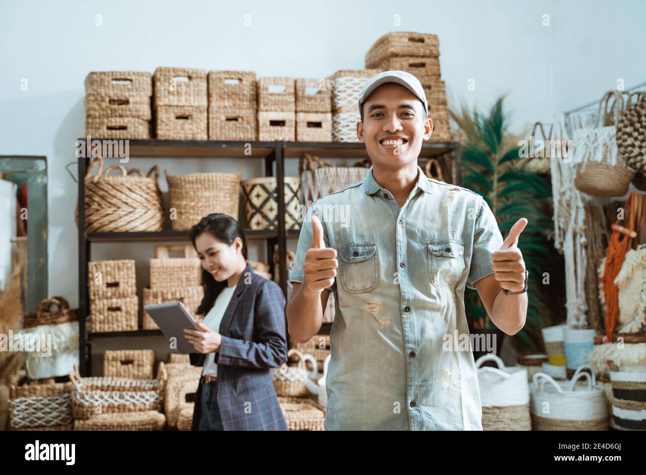 man stands with thumbs up among handicraft items on a casual woman's ...