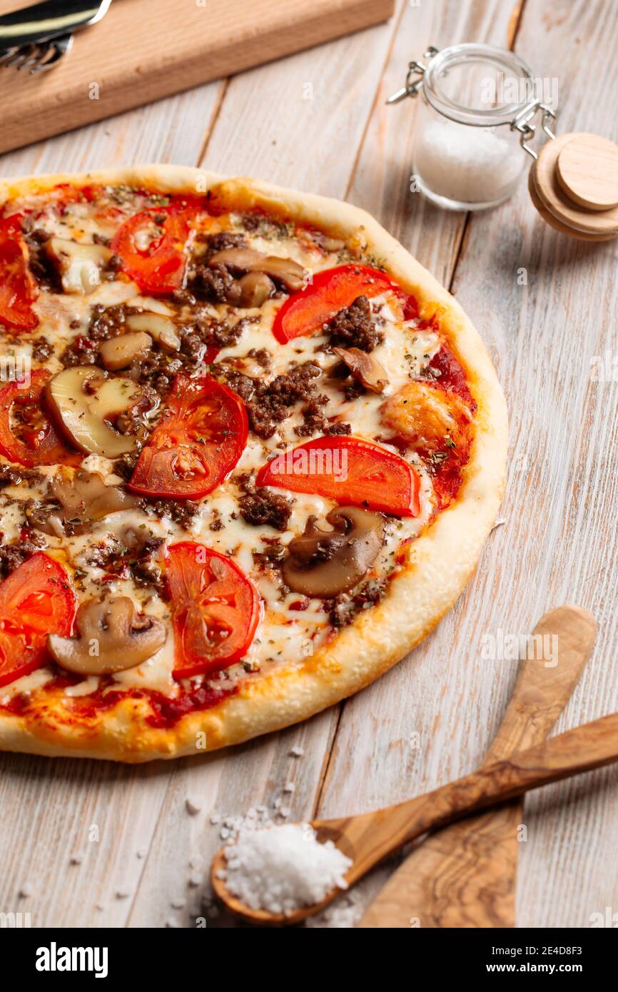 Minced meat pizza with mushrooms and tomatoes Stock Photo - Alamy
