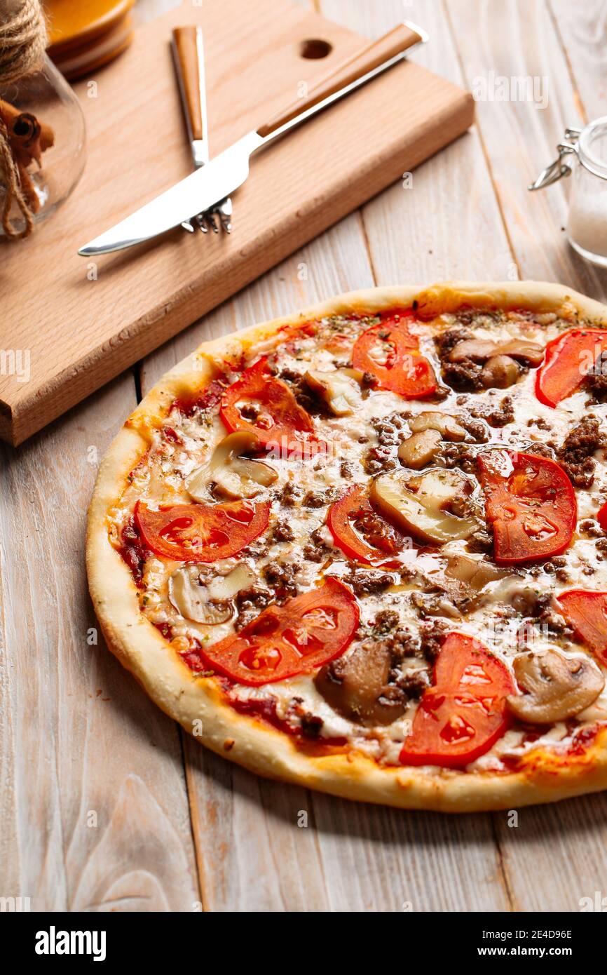 Minced meat pizza with mushrooms and tomatoes Stock Photo - Alamy