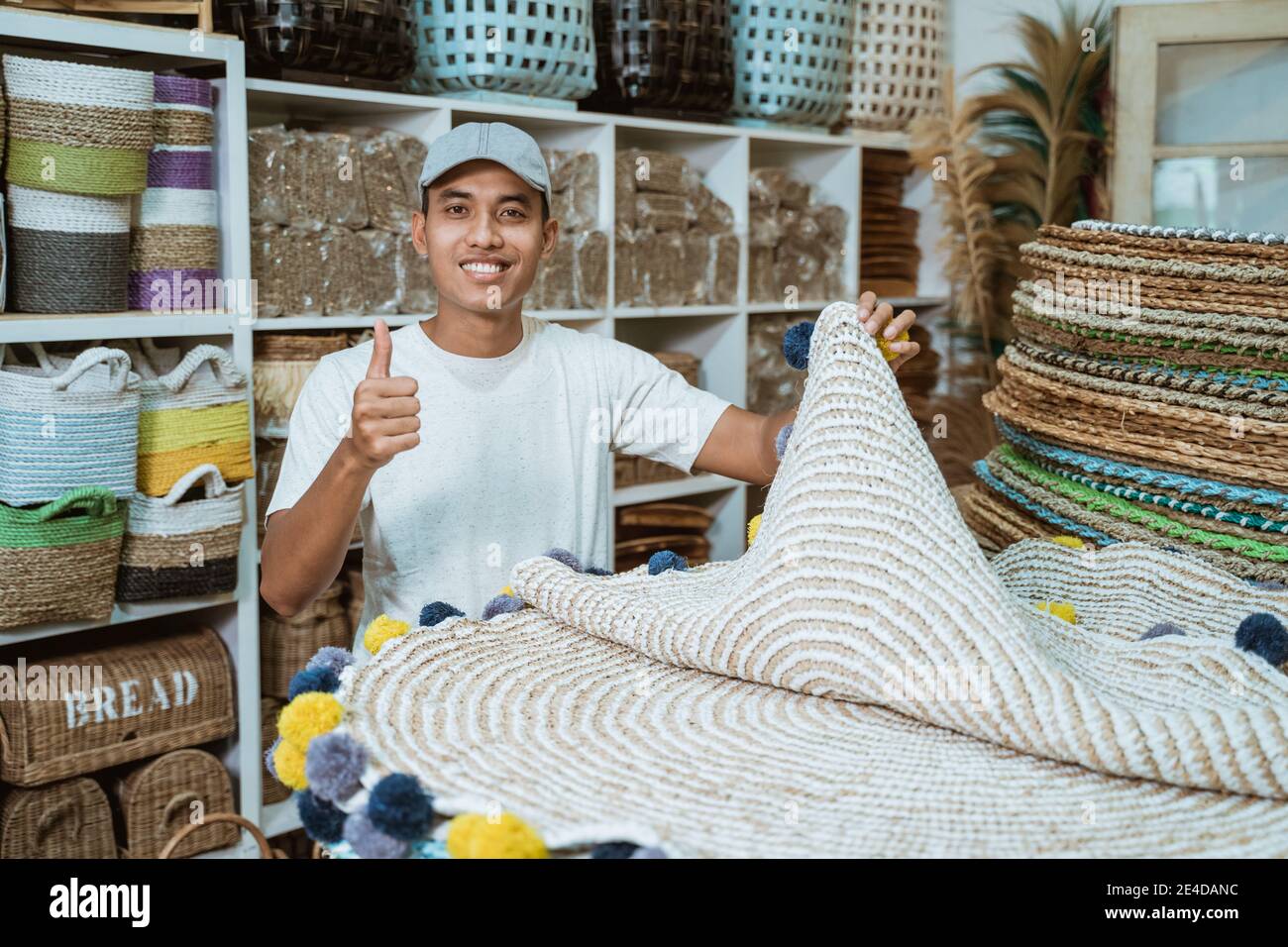 man with thumbs up holding knit carpet craft among craft items in craft ...