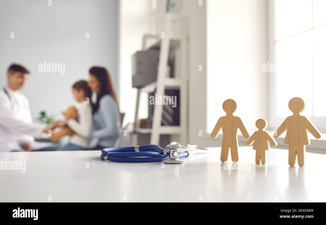 Blurred background with small family member figures on doctor's table ...