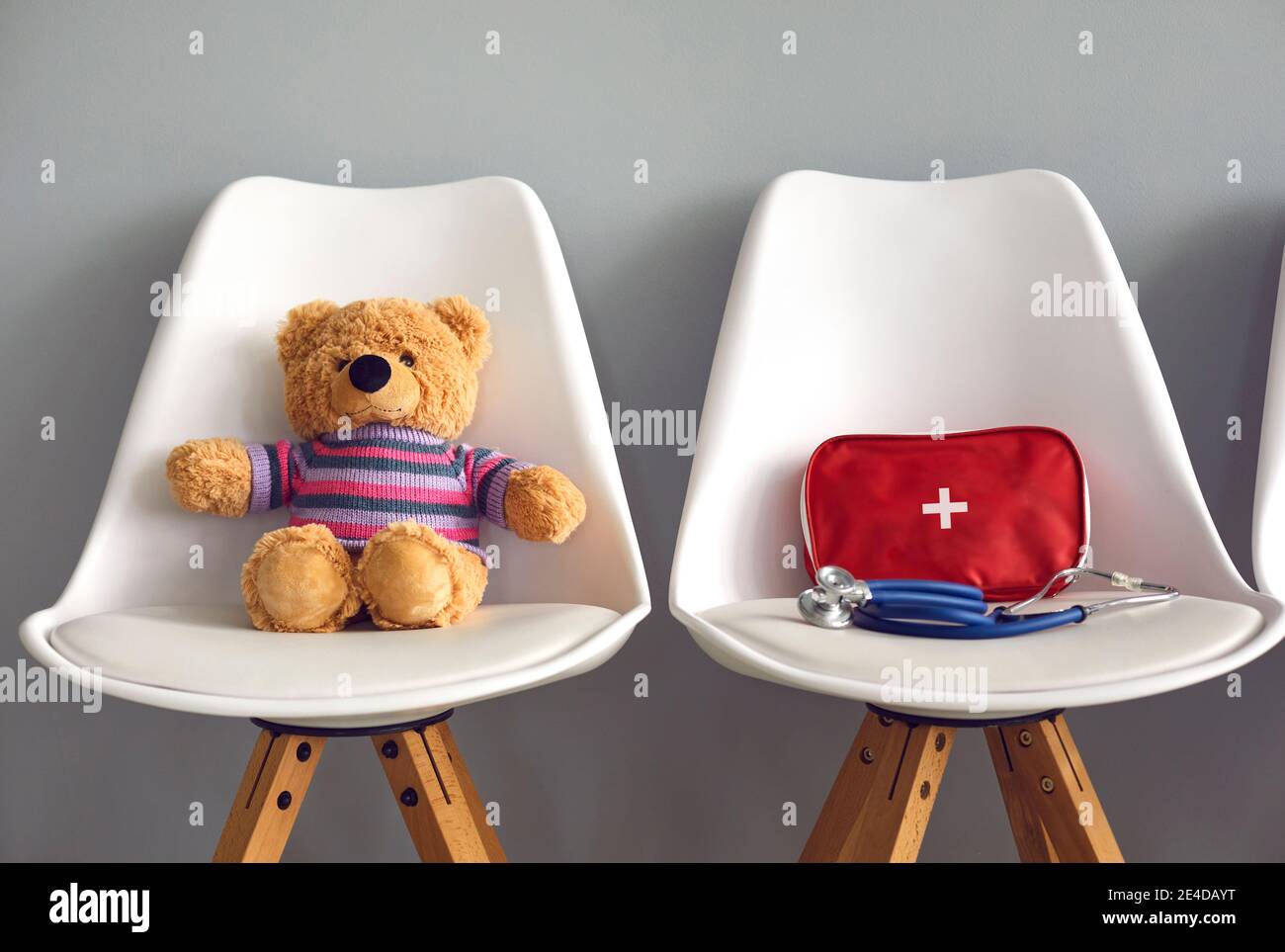 Teddy bear, first-aid kit and stethoscope on two chairs in pediatric ...