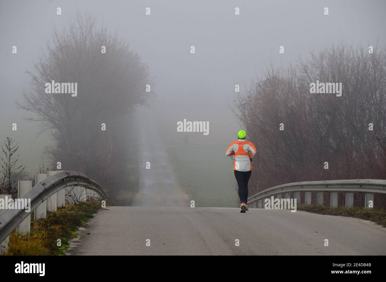 colorful runner in the fog and winter Stock Photo - Alamy