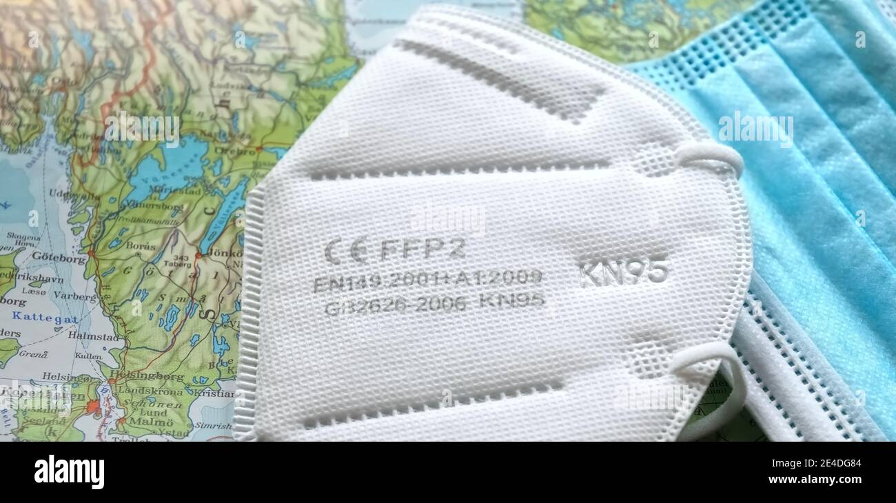 A single medical face mask and a FFP2 mask on a map as a symbol for ...
