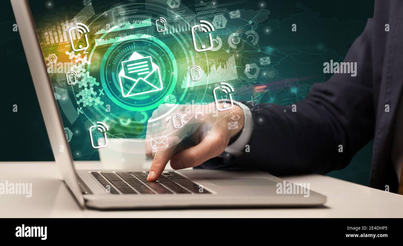 Business hand typing on a modern laptop with mailing icon coming out ...