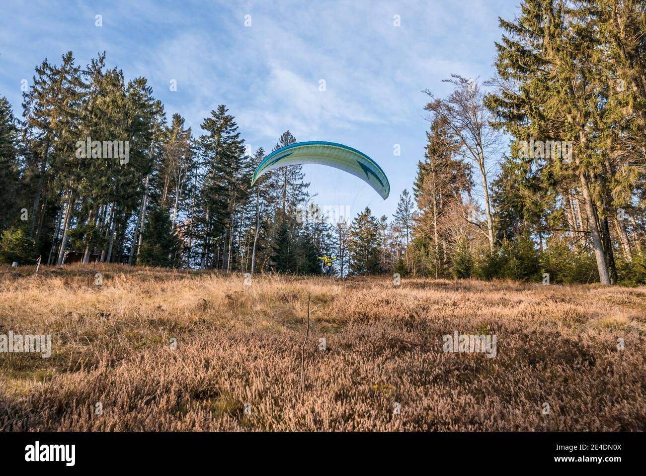 Taking off hobby paraglider pilot on a mountain slope with professional ...