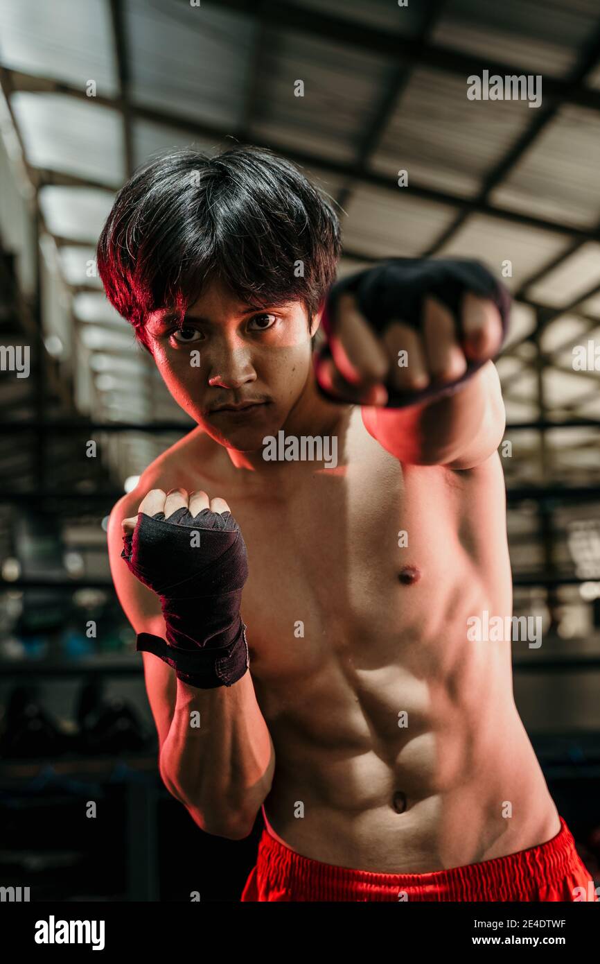 muscled boxer wearing black strap on wrist with do the warm-up punch ...