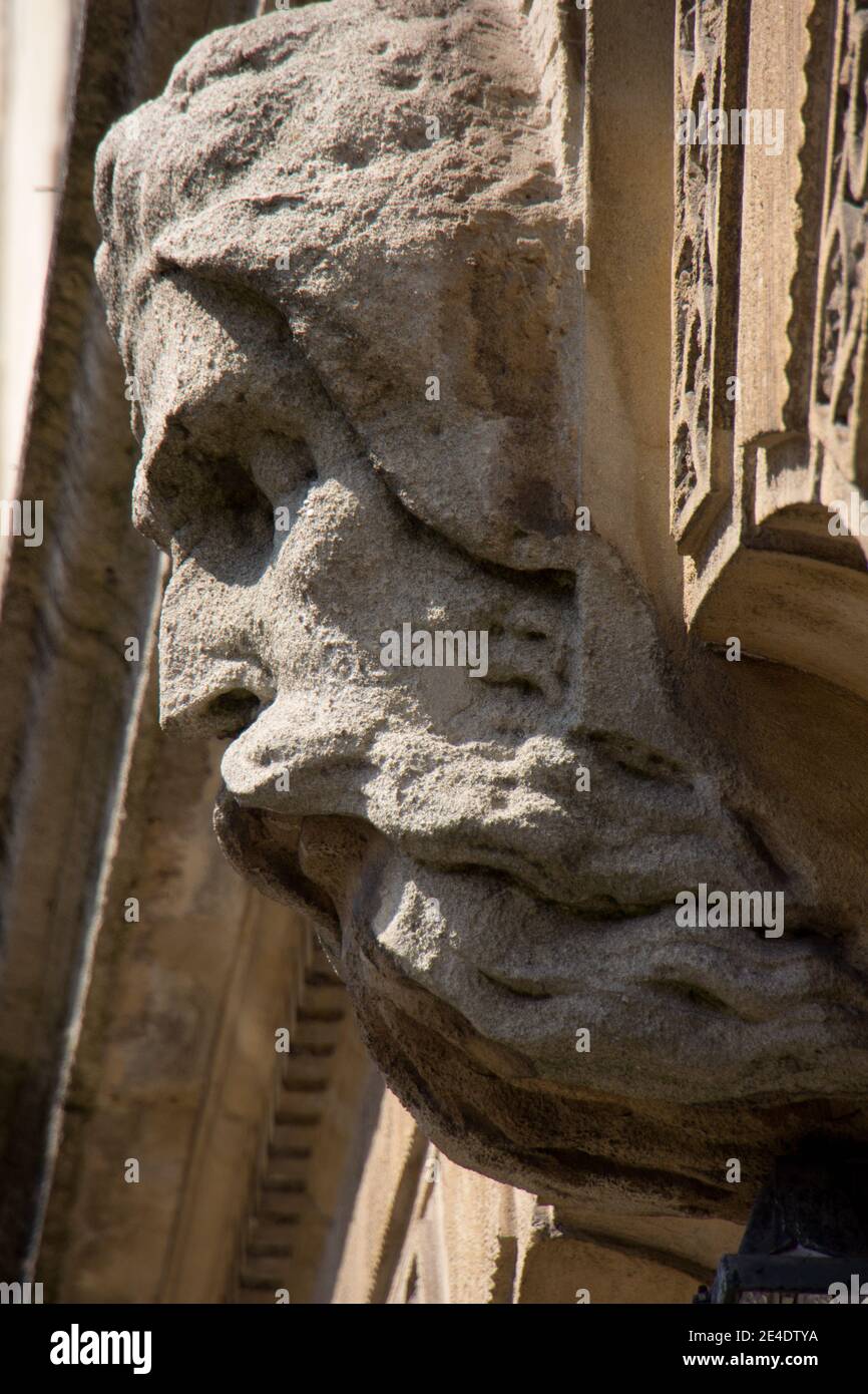a carved stone head on the side of a building Stock Photo - Alamy
