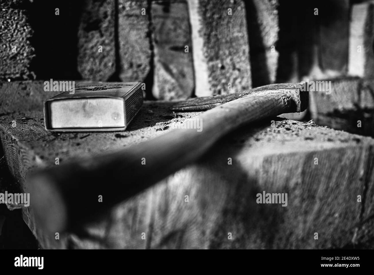 Grayscale shot of an axe with along wooden handle and safety match box ...