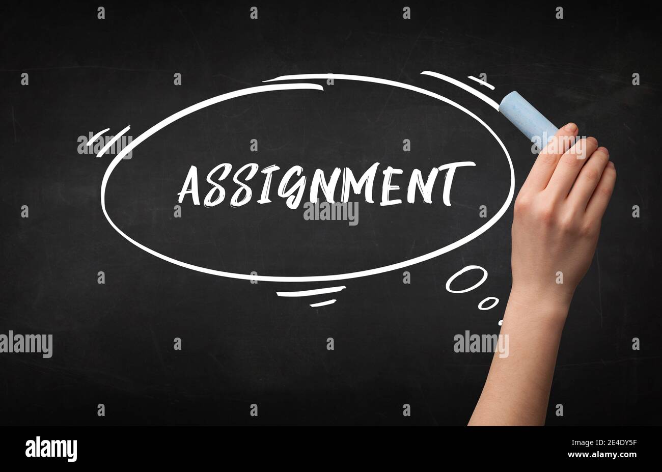 Hand drawing ASSIGNMENT inscription with white chalk on blackboard ...