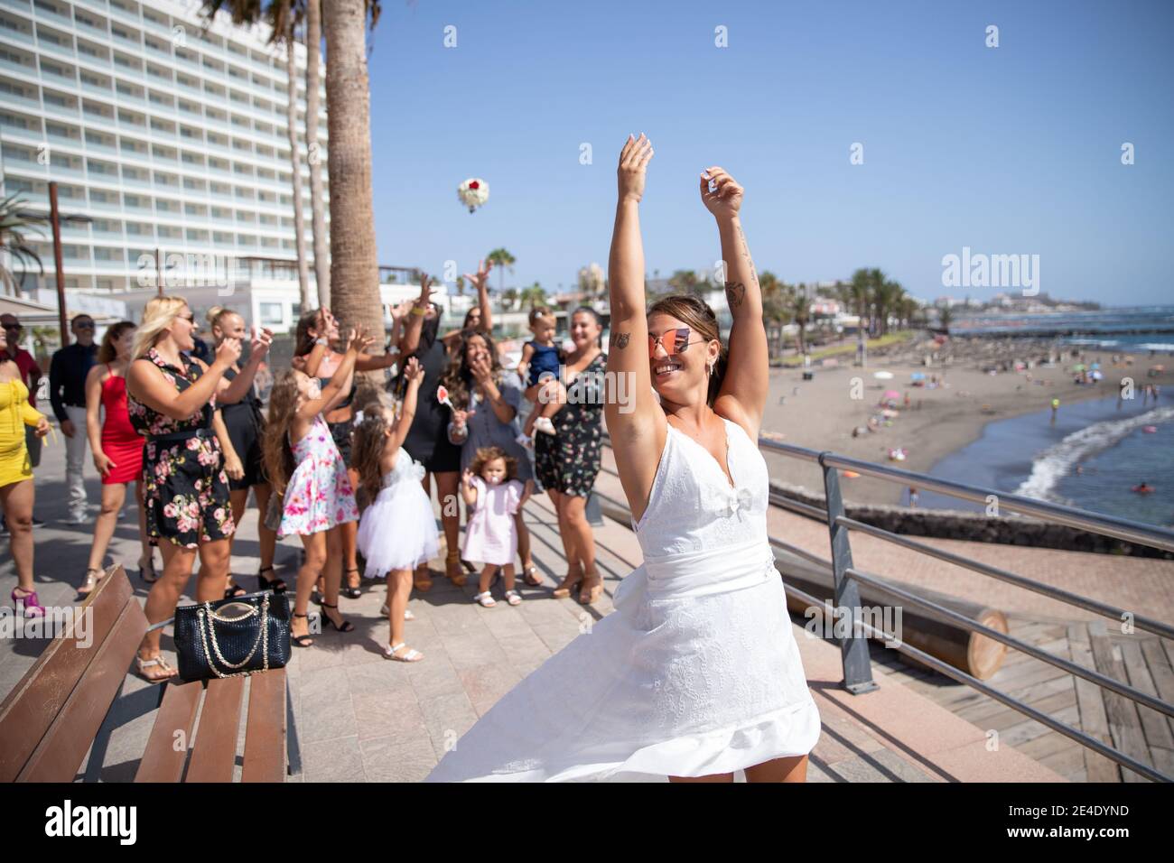 Wedding bouquet throwing, the newlywed bride is throwing the flowers to ...