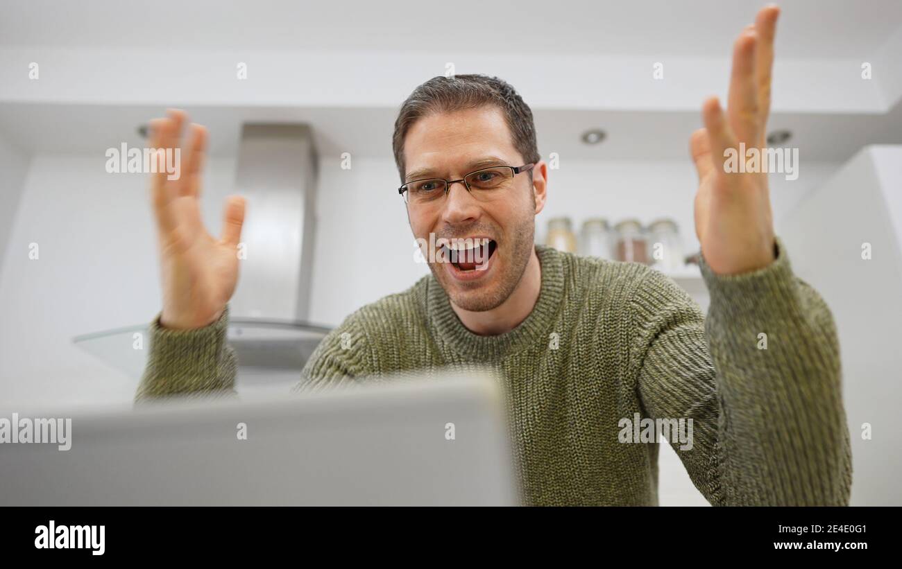 Excited man in front of laptop. Online gaming concept Stock Photo - Alamy