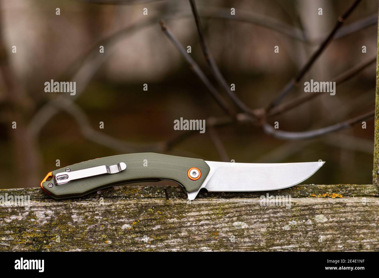 A knife with a wavy shape. Knife with a clip lying on the window. Front ...