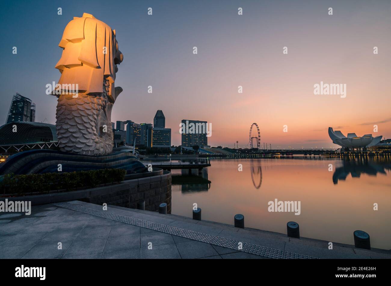 Merlion statue fountain in Merlion Park at sunrise. Merlion fountain is ...