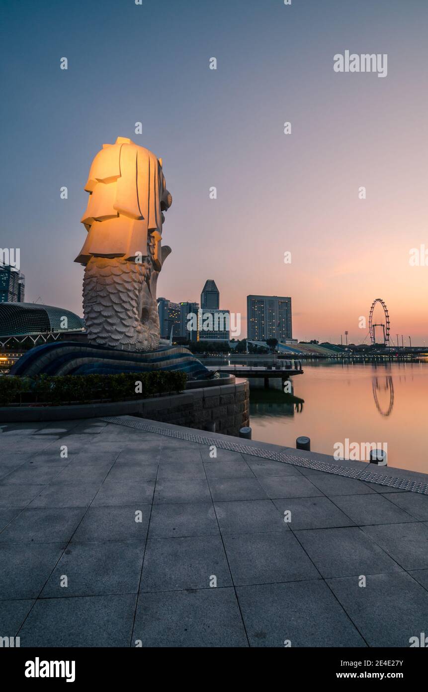 Merlion statue fountain in Merlion Park at sunrise. Merlion fountain is ...
