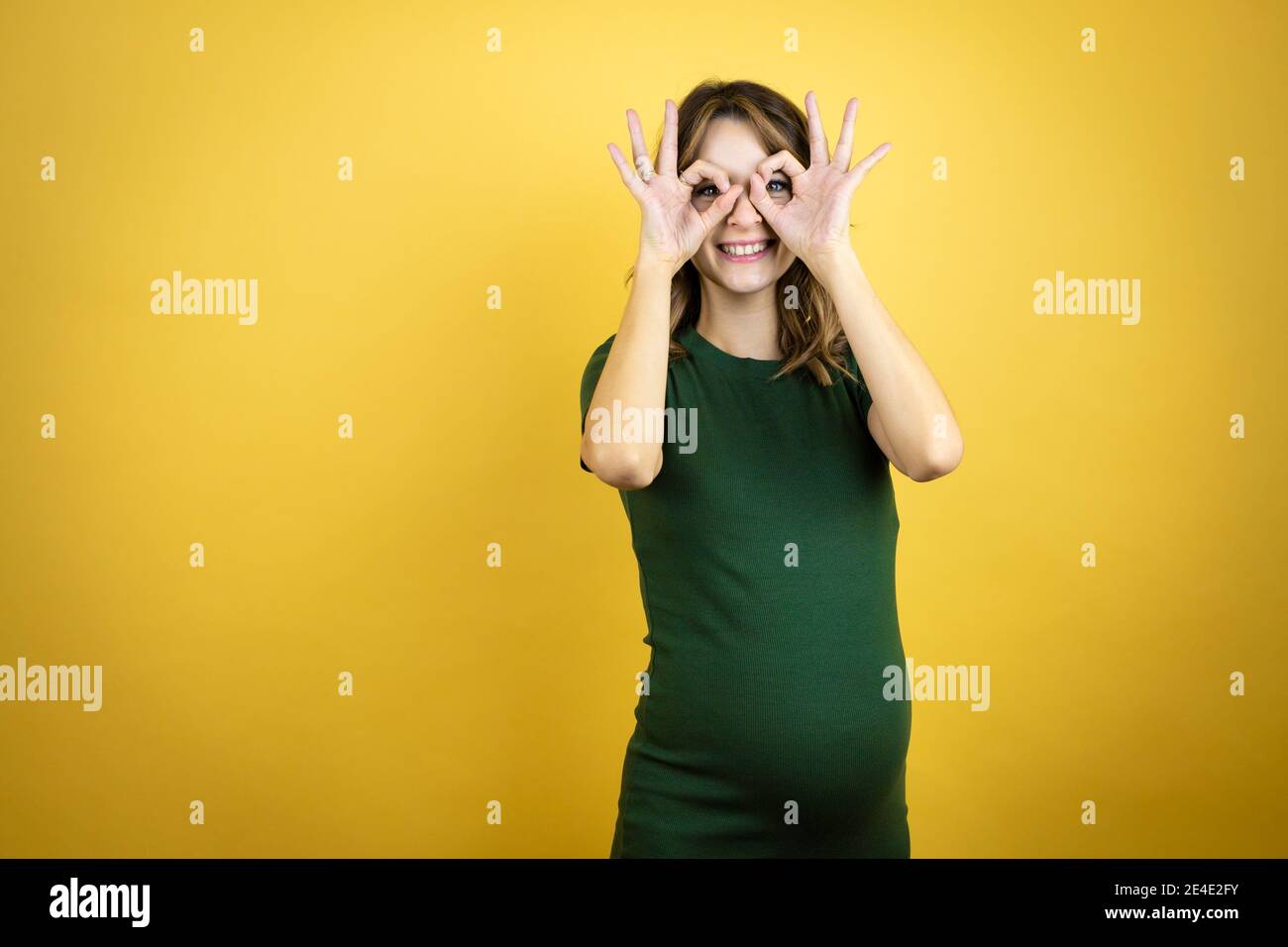 Young beautiful brunette woman pregnant expecting baby over isolated ...