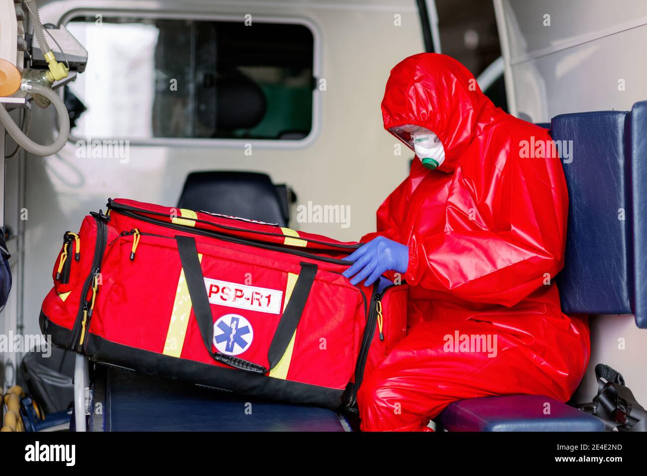 Male paramedic with face mask helping a patient with respirator in ...