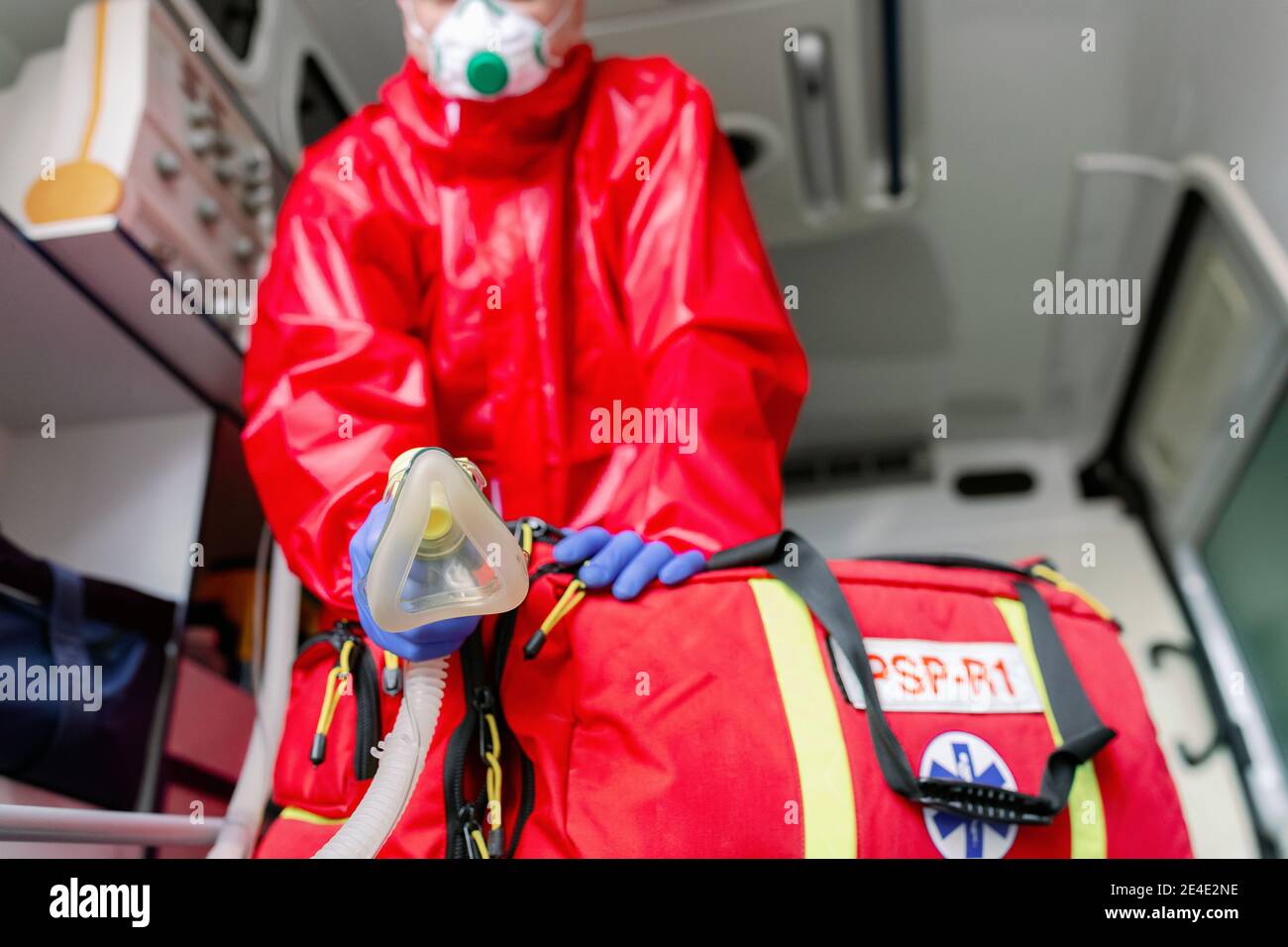 Male paramedic with face mask helping a patient with respirator in ...