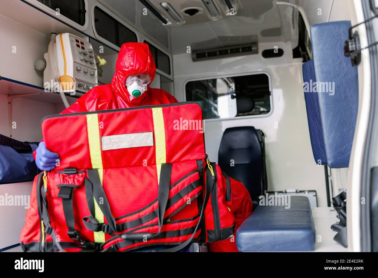 Male paramedic with face mask helping a patient with respirator in ...