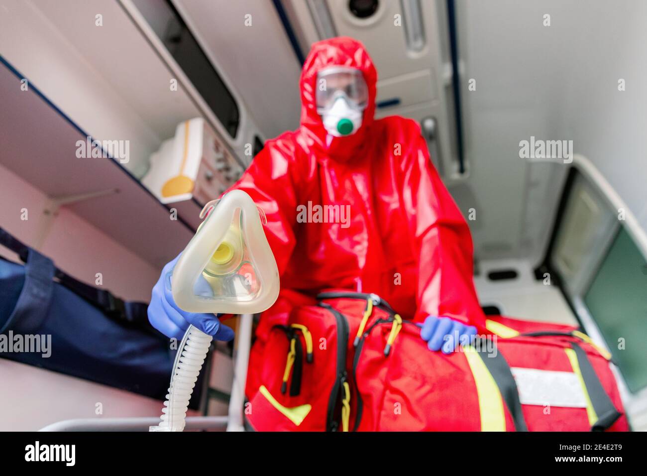 Male paramedic with face mask helping a patient with respirator in ...