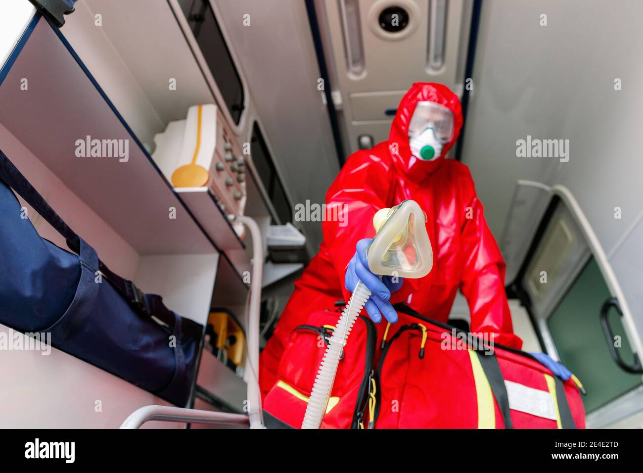 Male paramedic with face mask helping a patient with respirator in ...