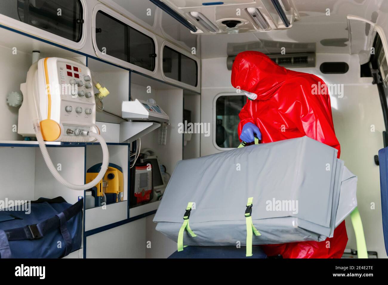 Male paramedic with face mask helping a patient with respirator in ...