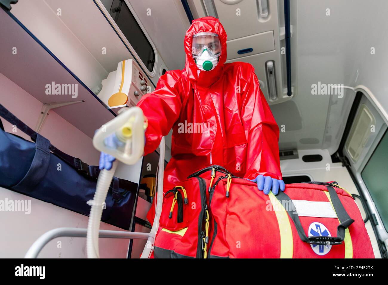 Male paramedic with face mask helping a patient with respirator in ...
