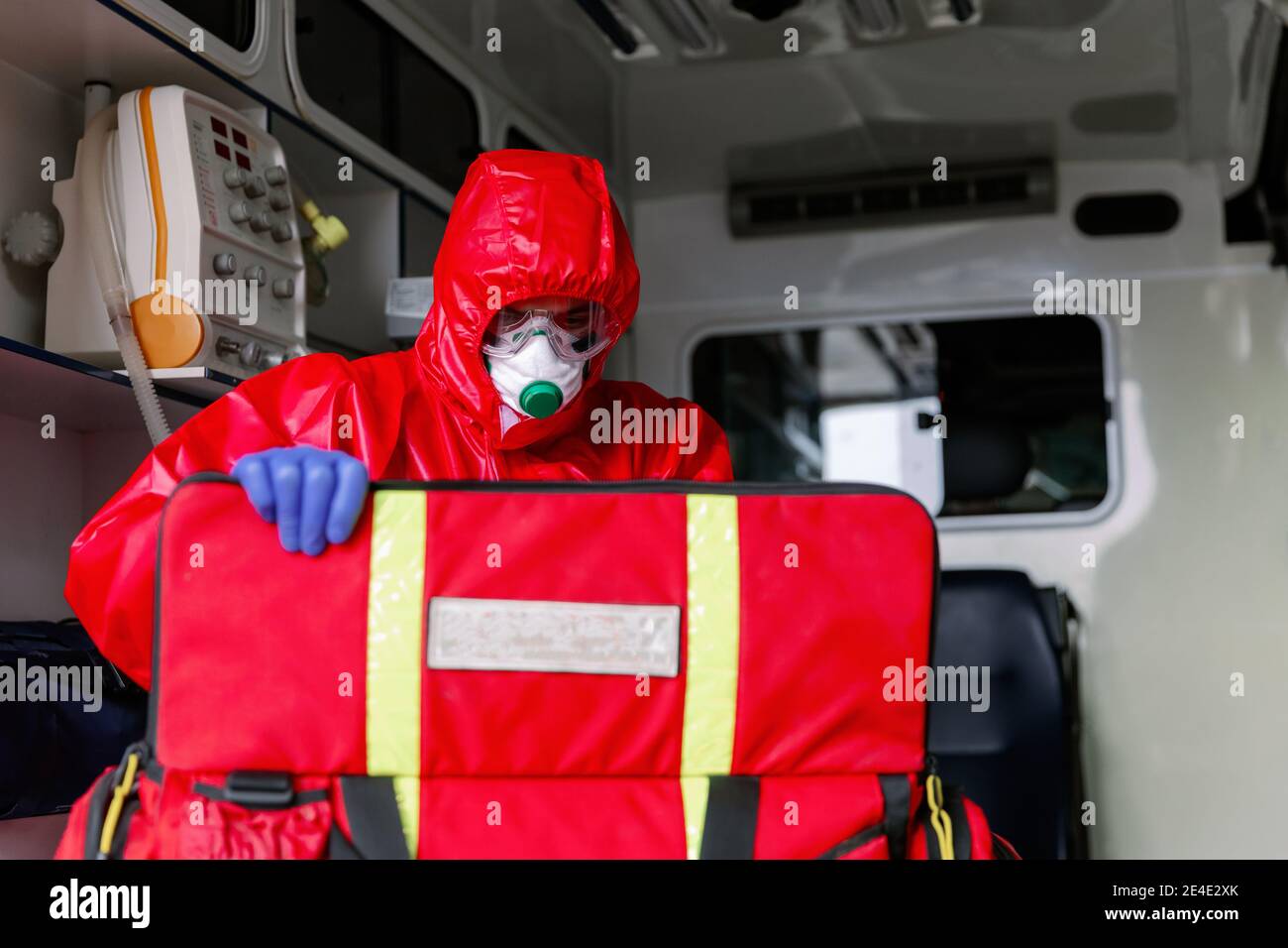 Male paramedic with face mask helping a patient with respirator in ...