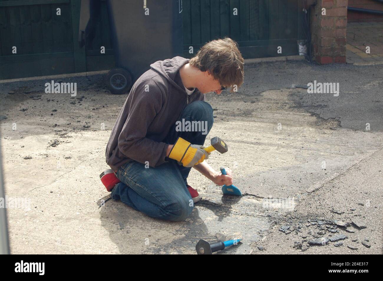 Builder chopping floor with hammer and chisel Stock Photo - Alamy