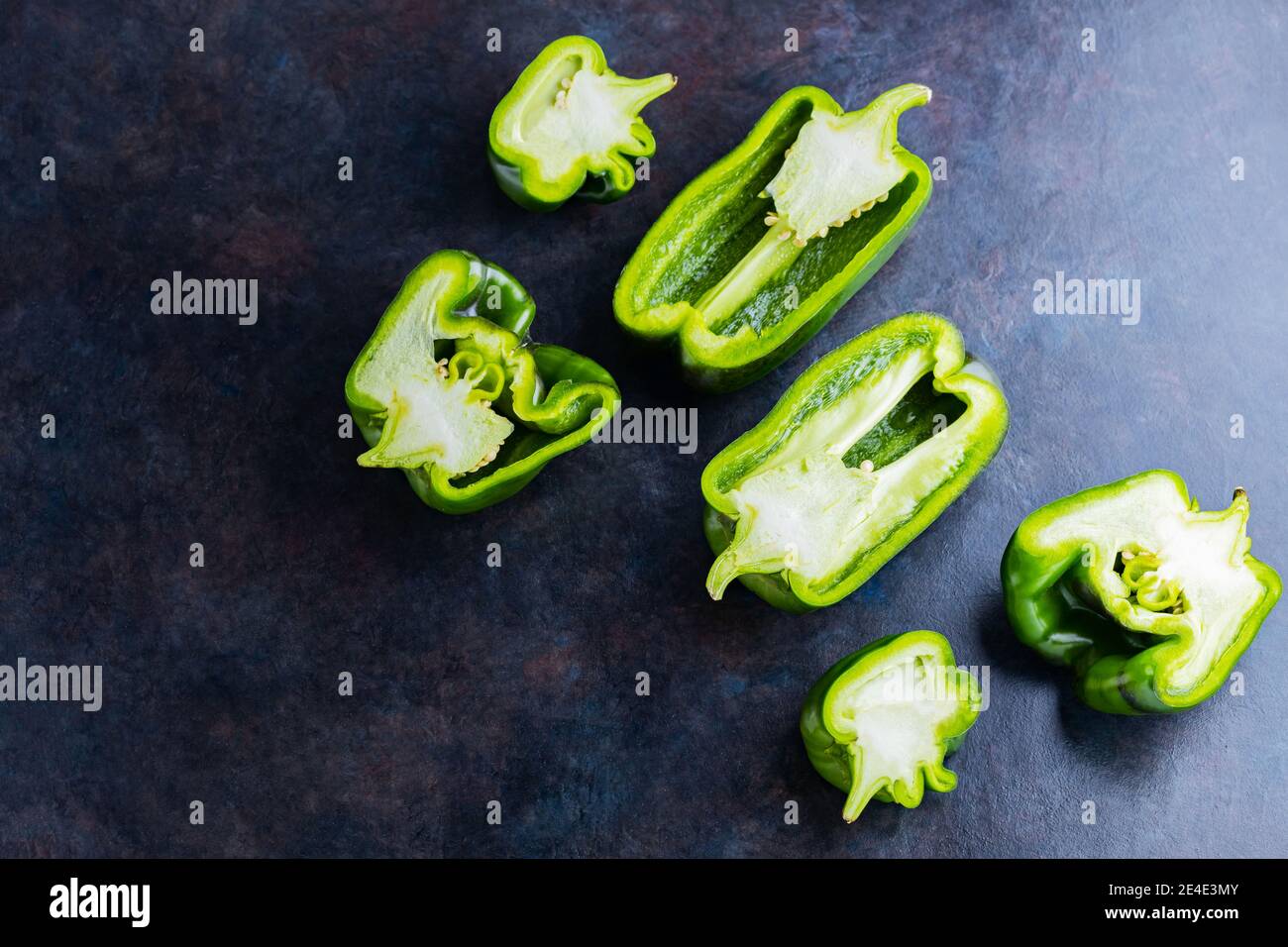 Ugly bell pepper on dark background. Sliced bell pepper halves on the ...
