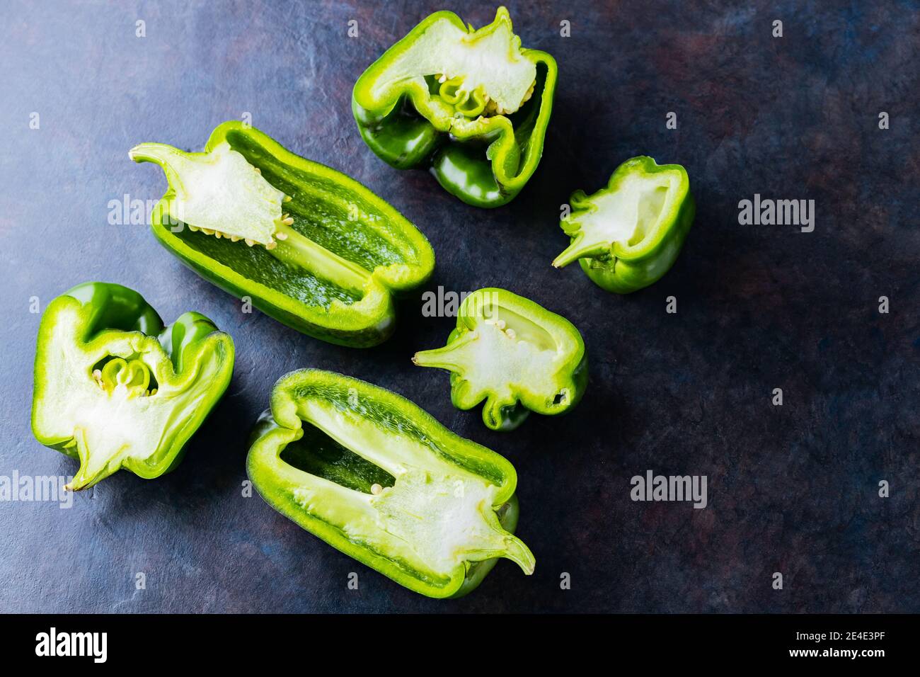 Ugly bell pepper on dark background. Sliced bell pepper halves on the ...