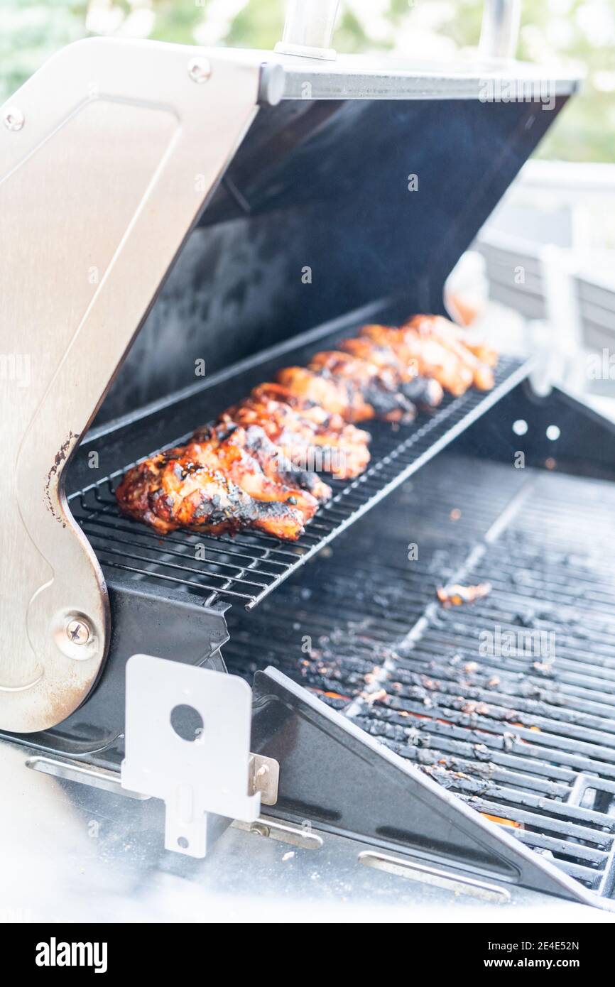 Grilling BBQ chicken drumsticks on outdoor gas grill Stock Photo - Alamy