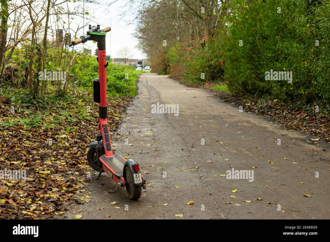 Battery powered electric scooter vehicle left on pedestrian footpath in ...
