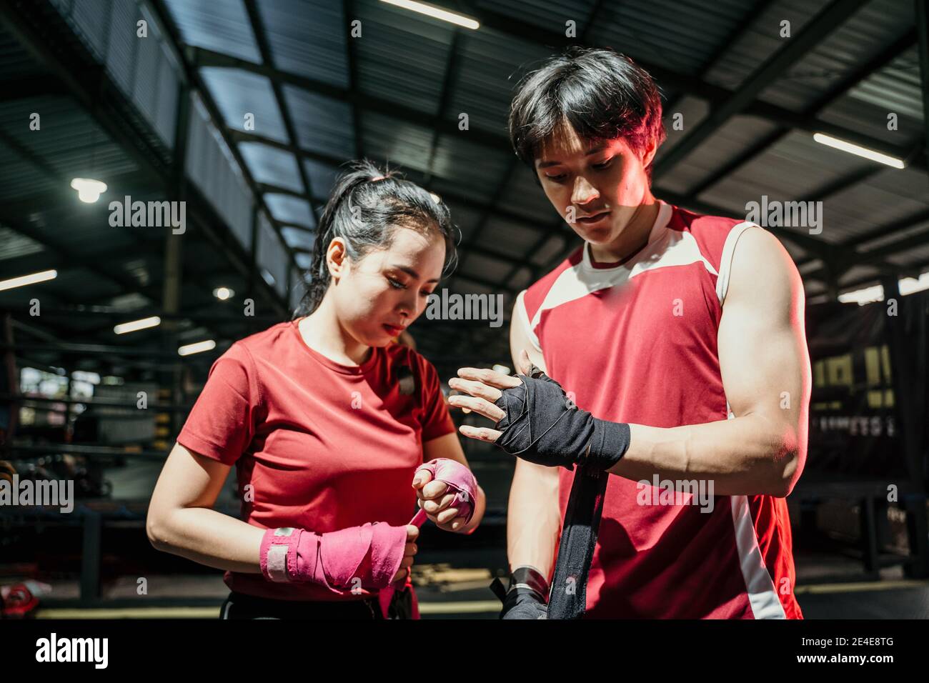 portrait of couple fighter applying bondage tape on hands over fighting ...
