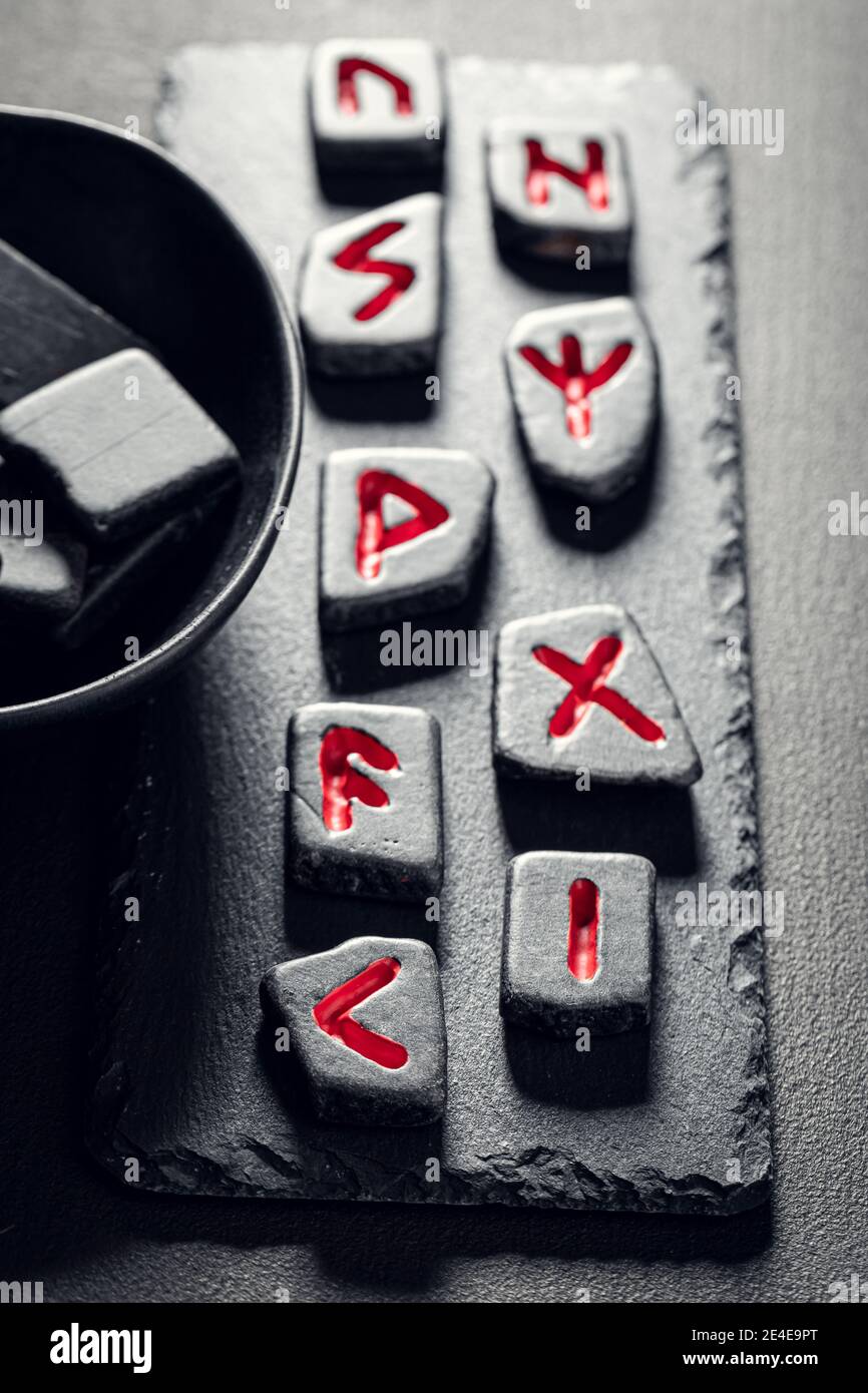 Closeup of old magic rune with red signs based on futhark alphabet ...