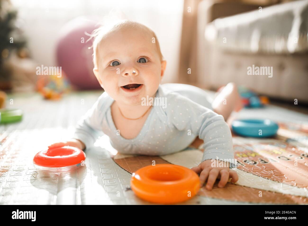 Wonderful baby girl laying on colourful mat at home. Adorable cute ...