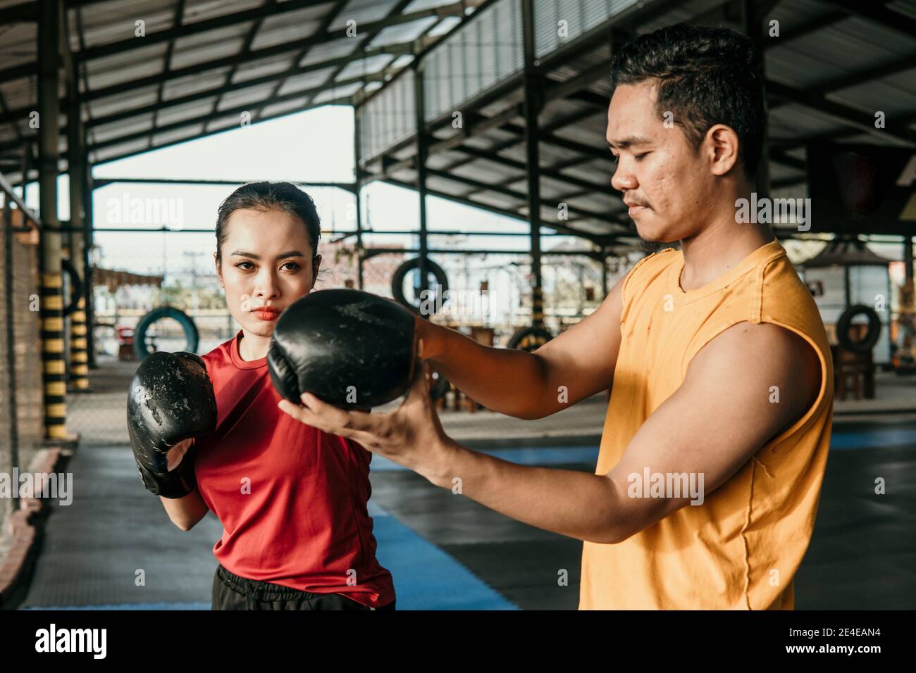 Trainer with a woman boxer standing together during a training Stock ...
