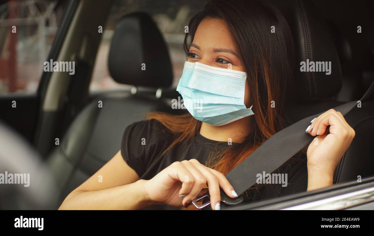 Hispanic female with face mask driving a car - concept of the new ...